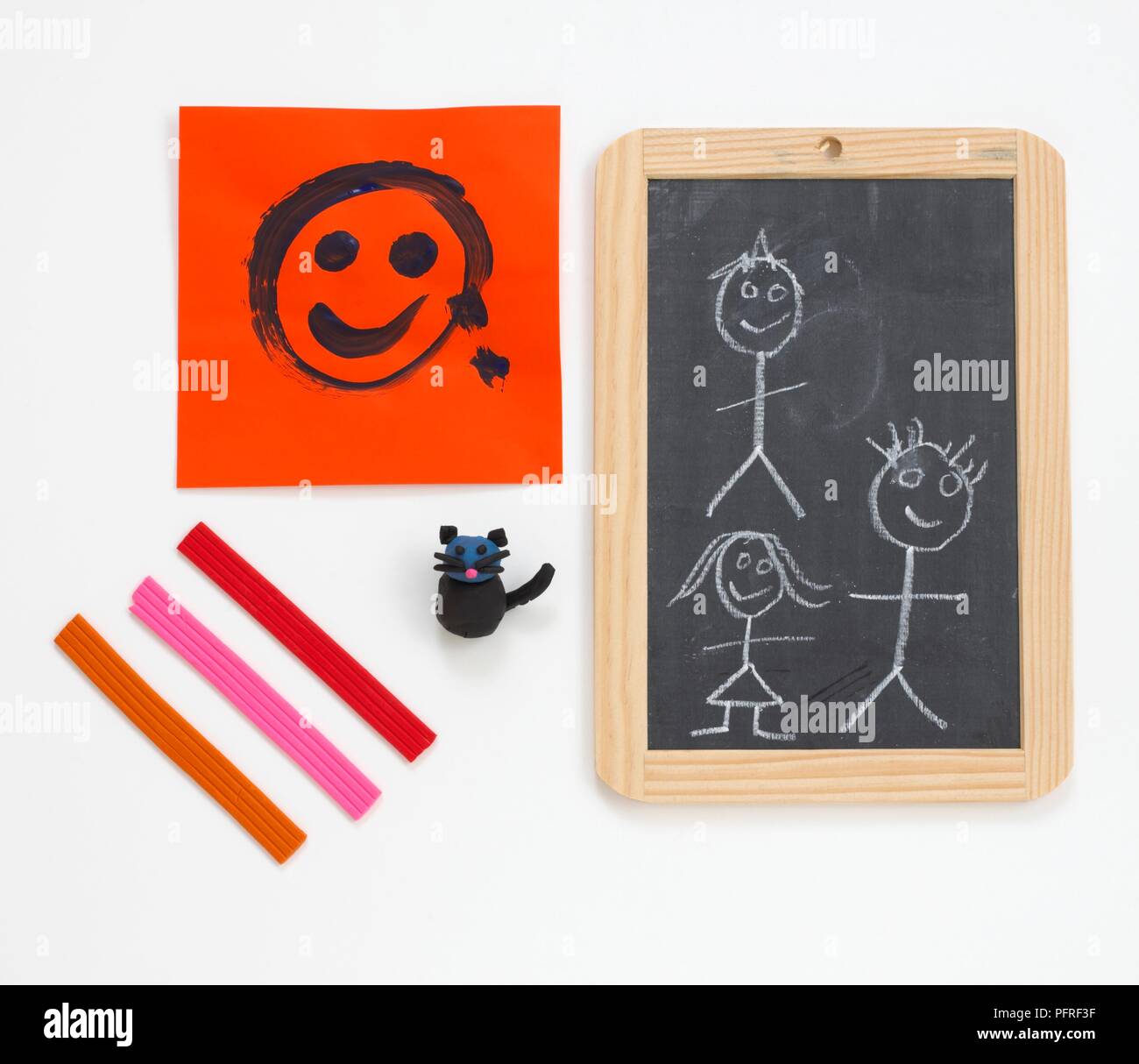 Chalk drawing on blackboard, smiley face on orange paper, three strips ...
