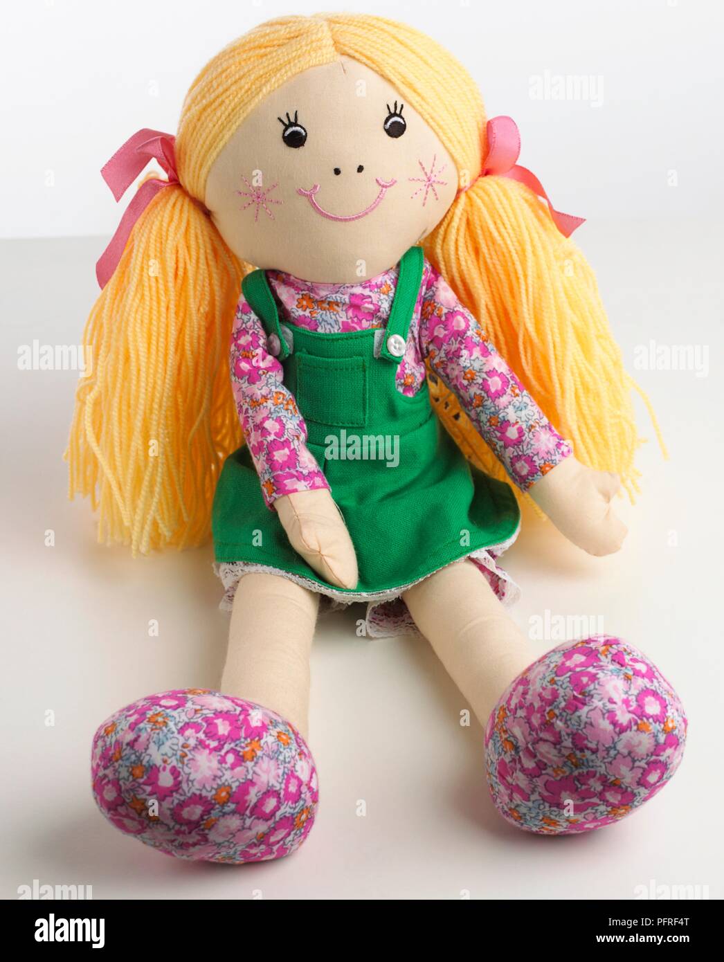 Rag doll with smiley face and blonde bunches tied with ribbon Stock ...