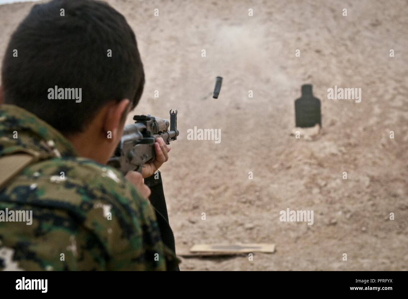 A Syrian Democratic Forces soldier fires his AK-47 assault rifle at a ...