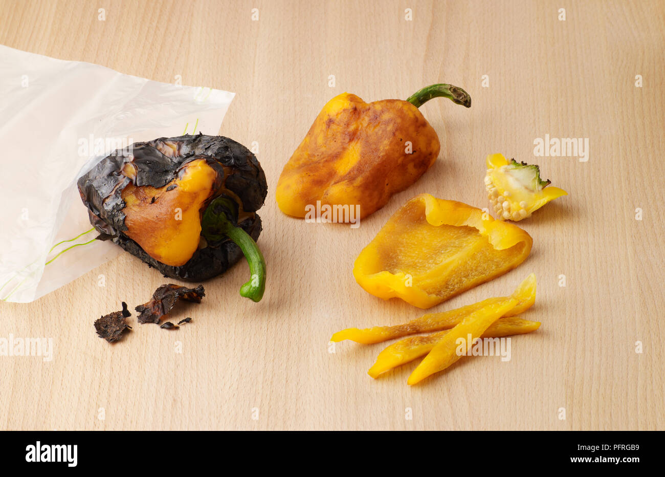 Charred yellow peppers, some with the charred skin peeled away and cut ...