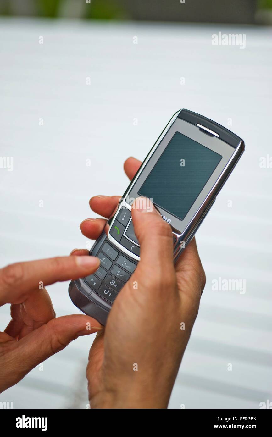 Hands holding mobile phone and using keypad Stock Photo - Alamy