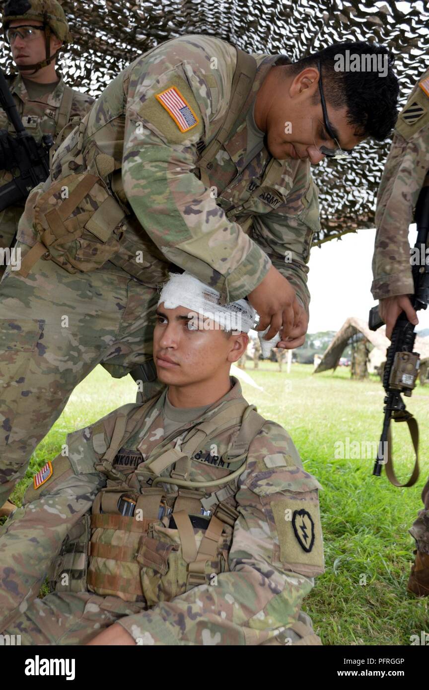 Spc. Filiberto Dominguez (standing) practices how to perform first aid ...