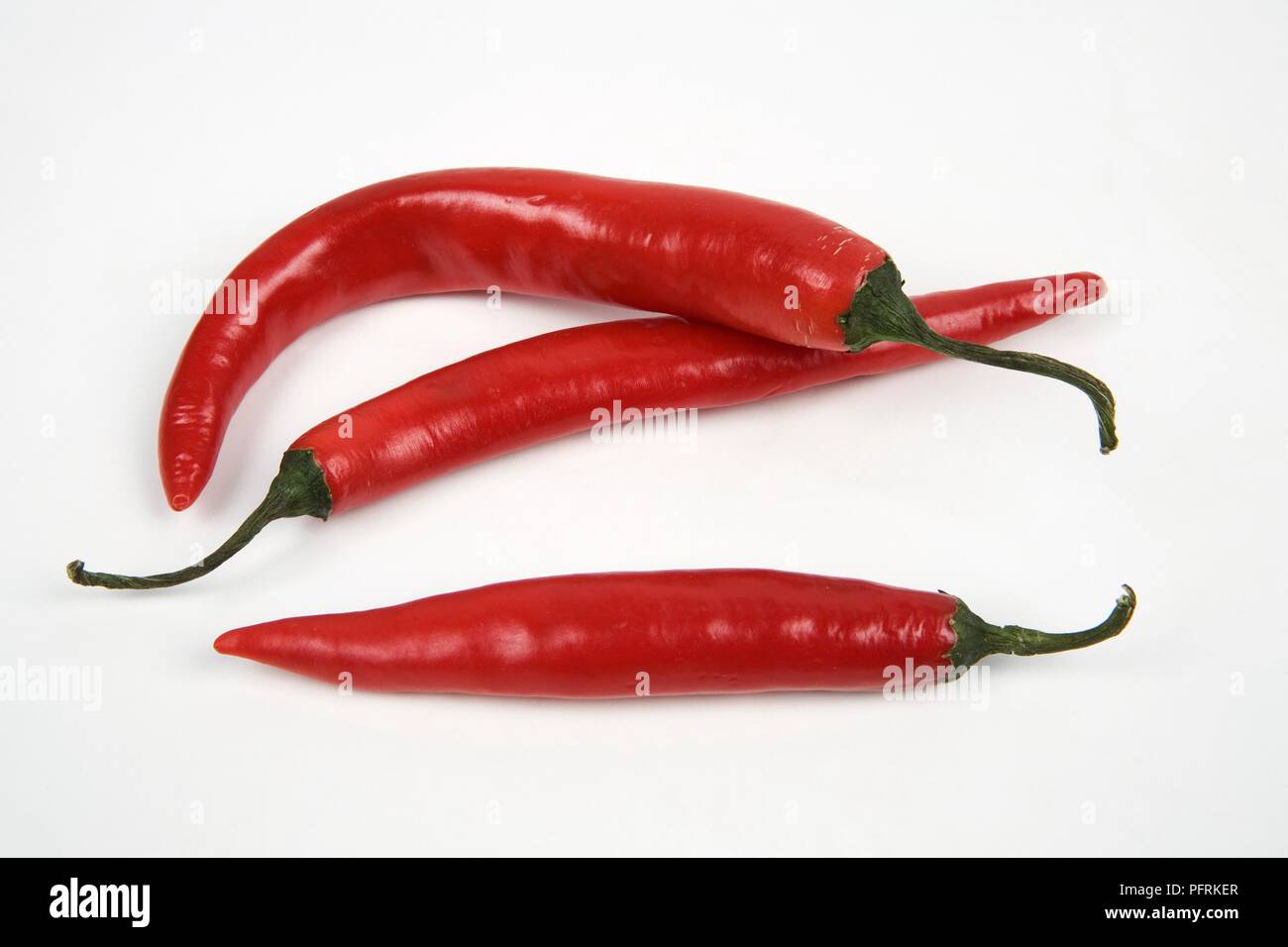 Three red cayenne chilli peppers Stock Photo - Alamy