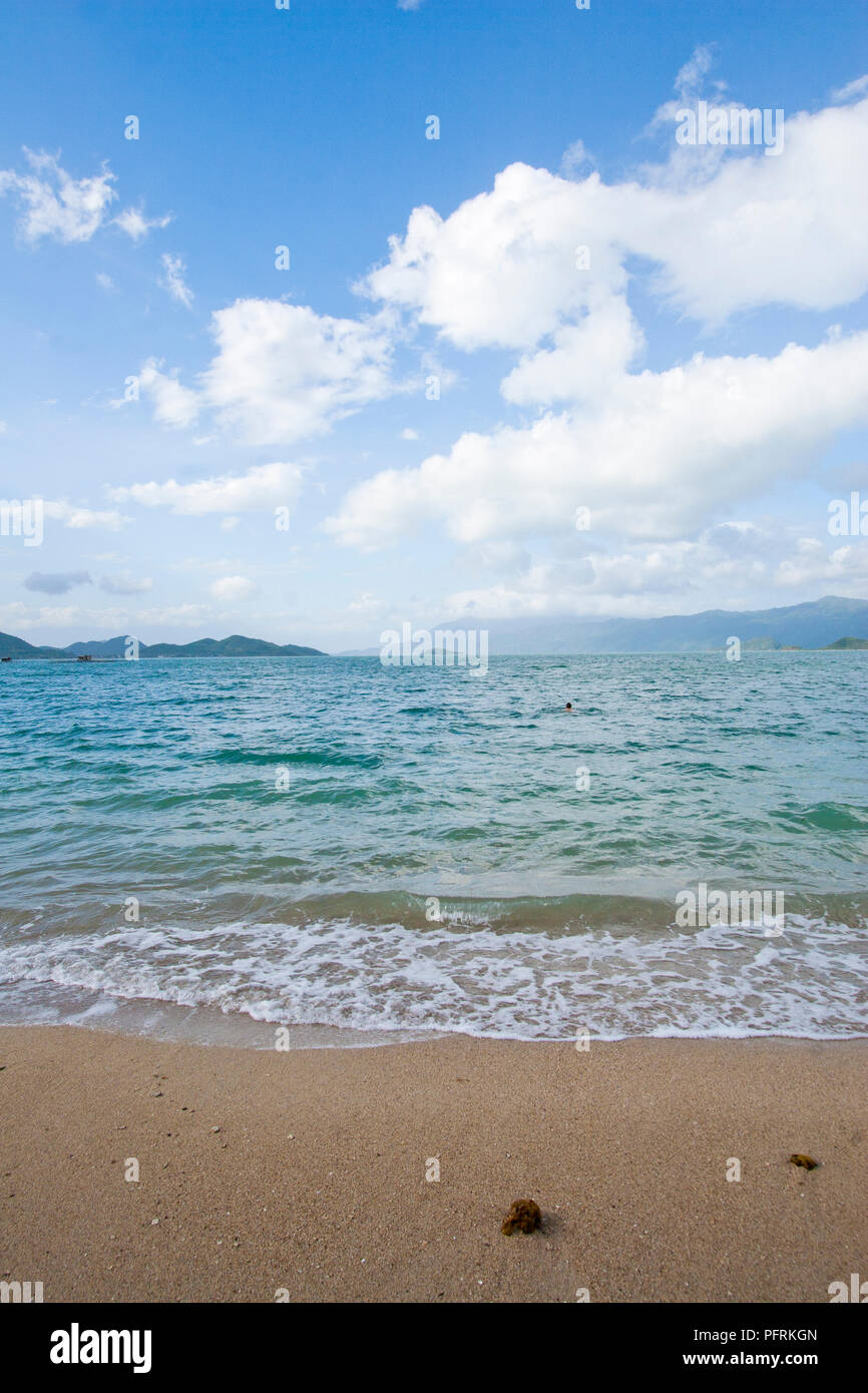Vietnam, Hon Lao (Monkey Island), waves rolling onto beach with blue ...