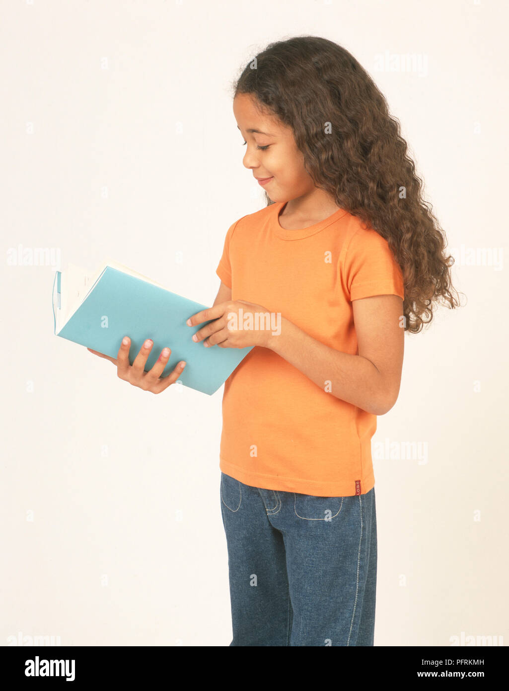 Girl standing reading a book Stock Photo - Alamy