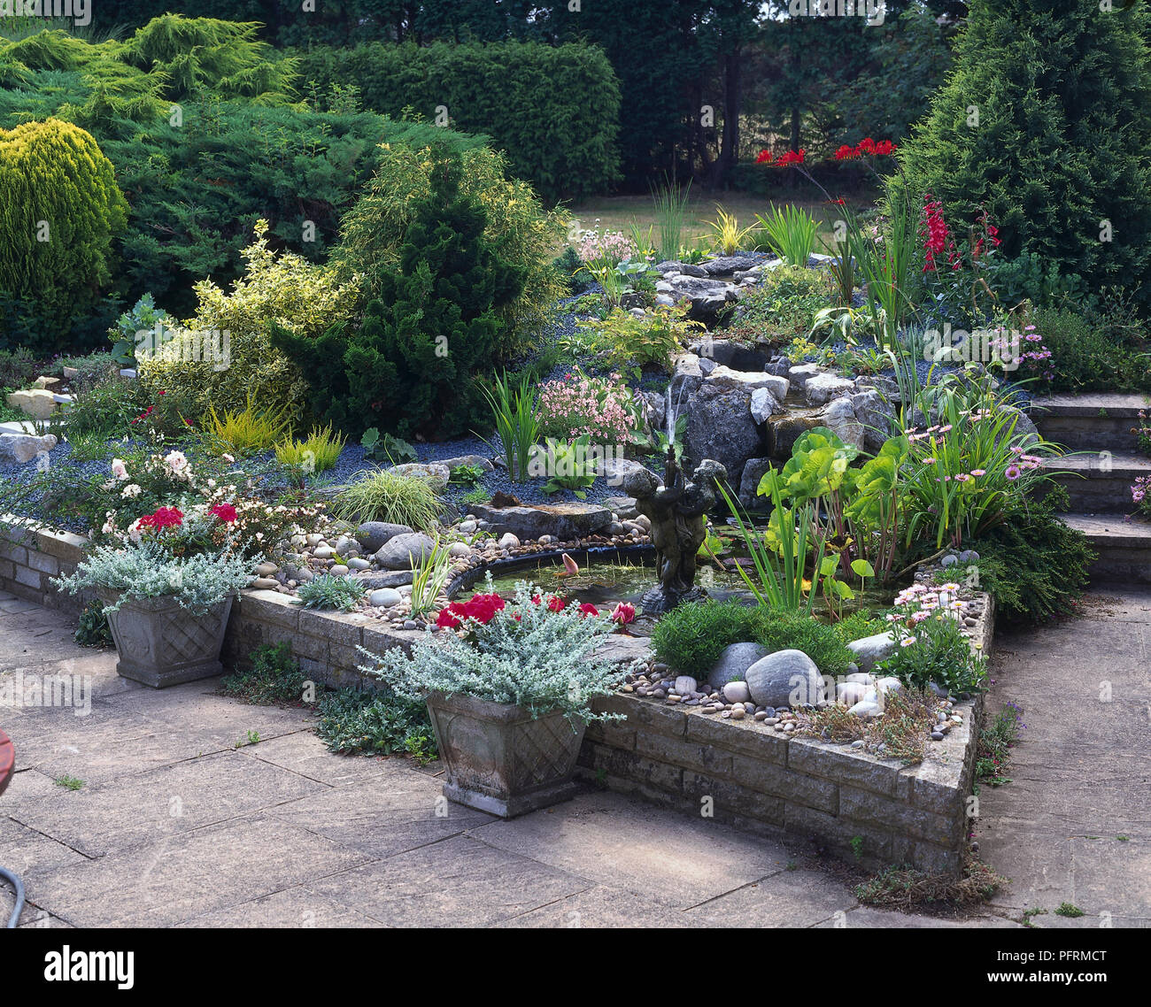 Water garden with stream flowing into pond Stock Photo - Alamy