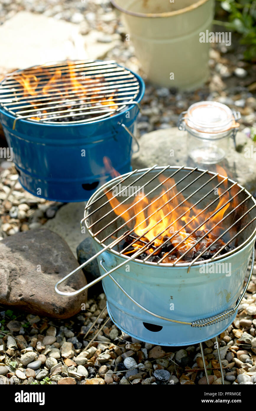 Two lit portable barbeque grills Stock Photo - Alamy