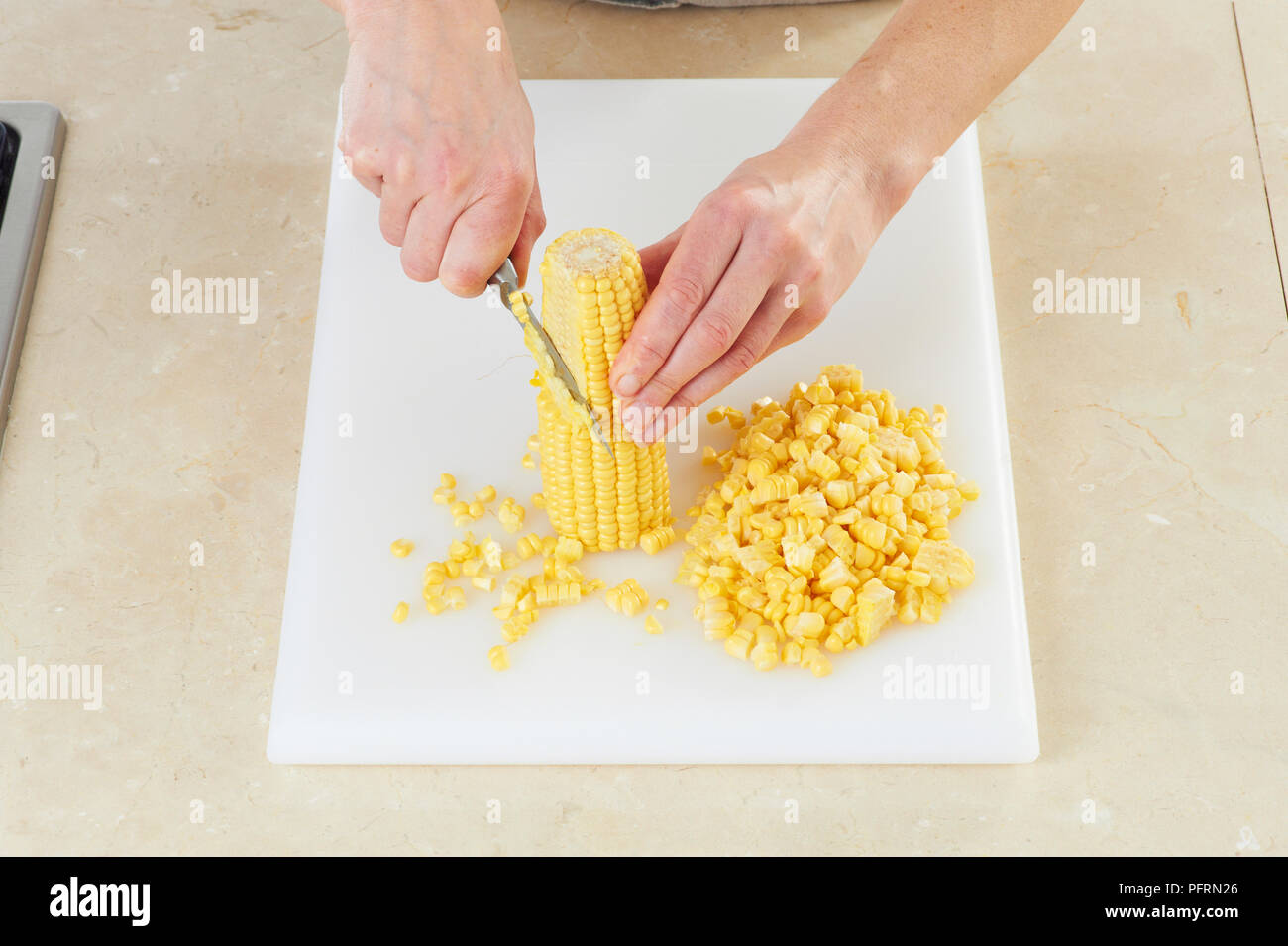 Removing kernels from corn cob, using a knife Stock Photo - Alamy