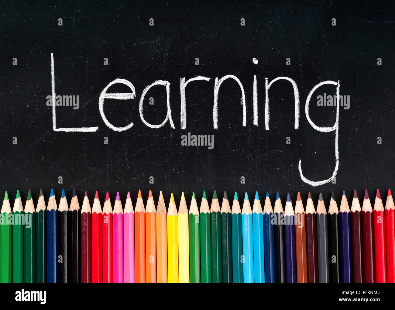 The word 'learning' written on a blackboard, below it a row of coloured ...