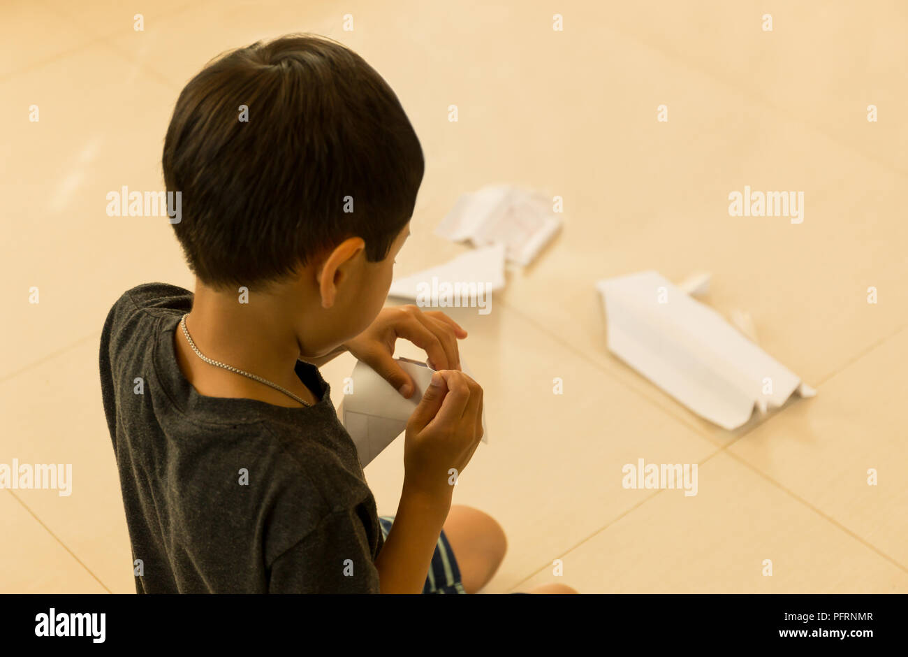 Little boy making paper plane Stock Photo - Alamy