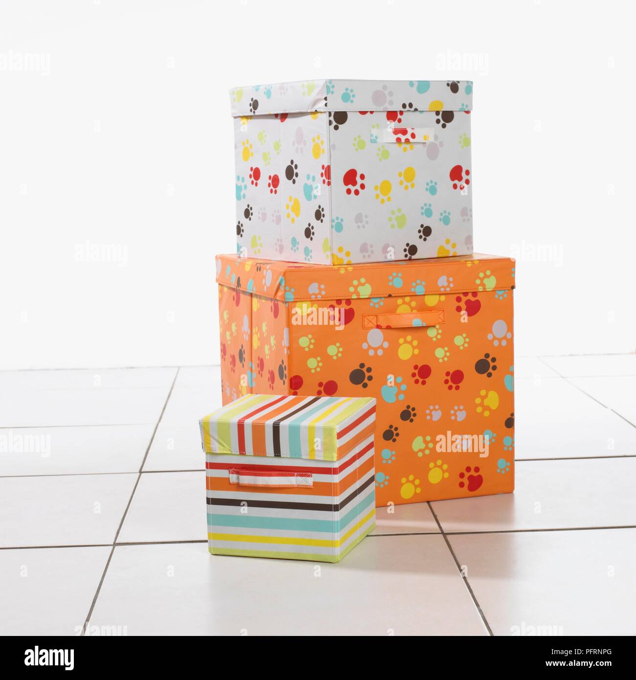 Striped and paw print pattern boxes on tiled floor Stock Photo - Alamy
