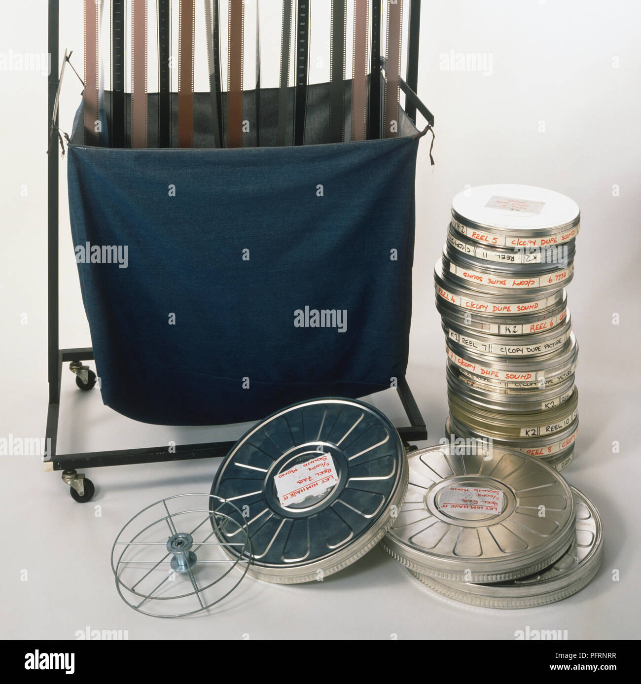 Strips of film hanging, and stack of reel cans Stock Photo - Alamy