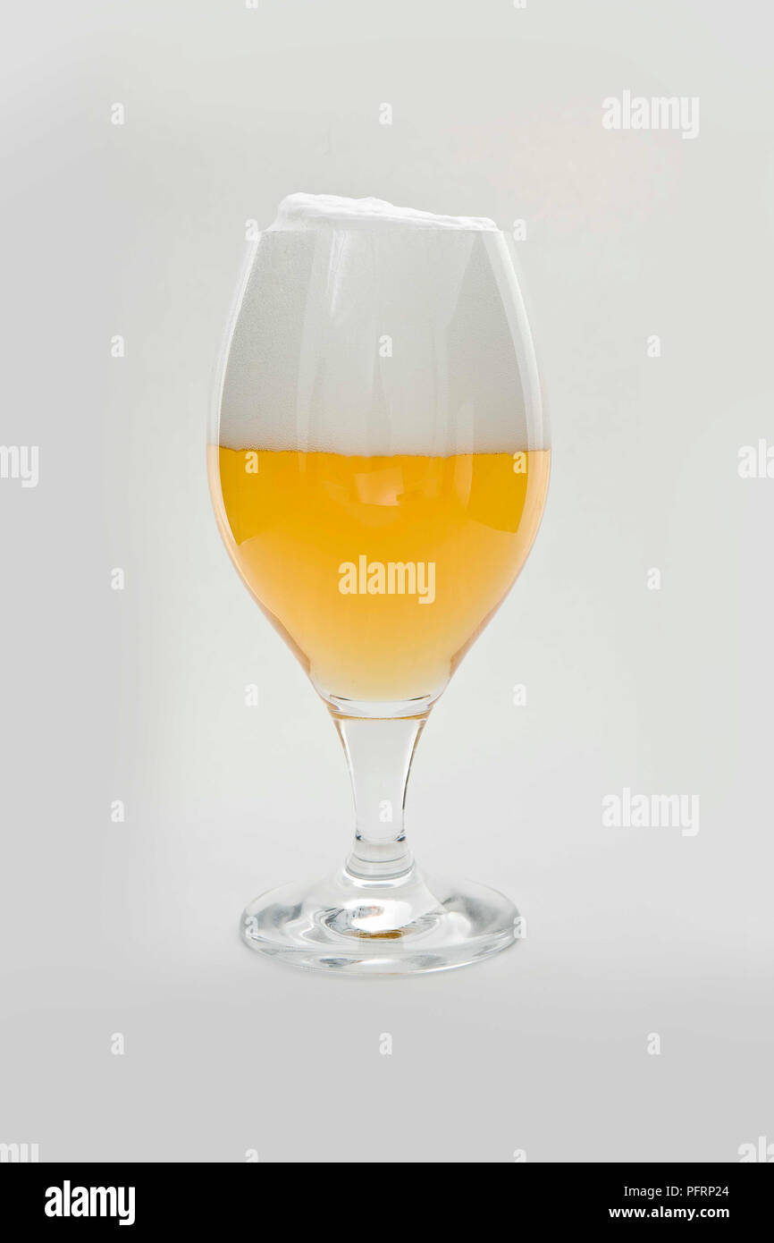 Glass of frothy Belgian beer Stock Photo - Alamy