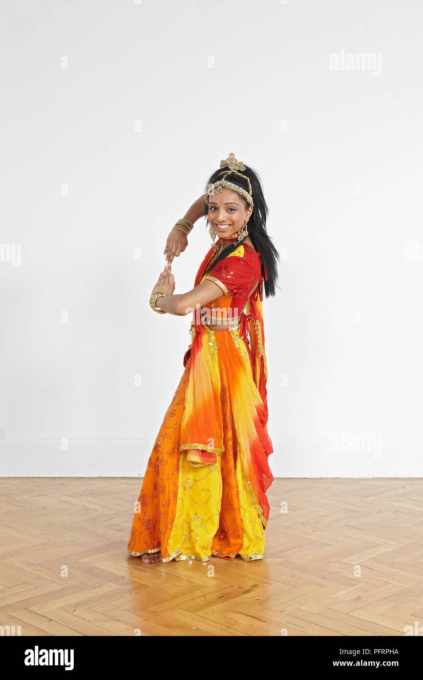Teenage girl performing Bollywood dance move (hands facing each other ...