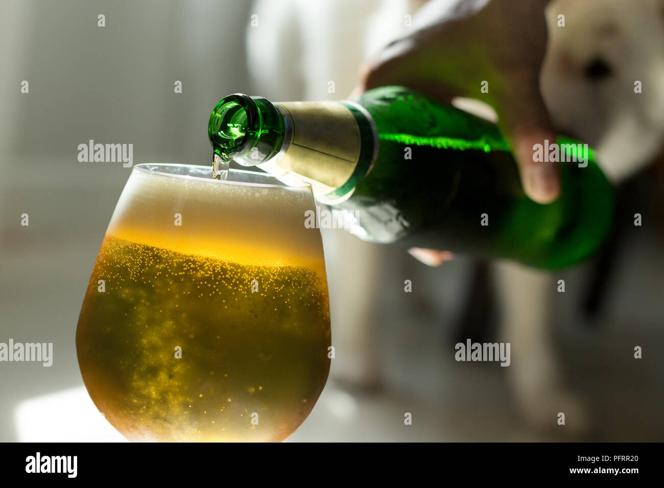 Hand pouring beer into glass Stock Photo - Alamy
