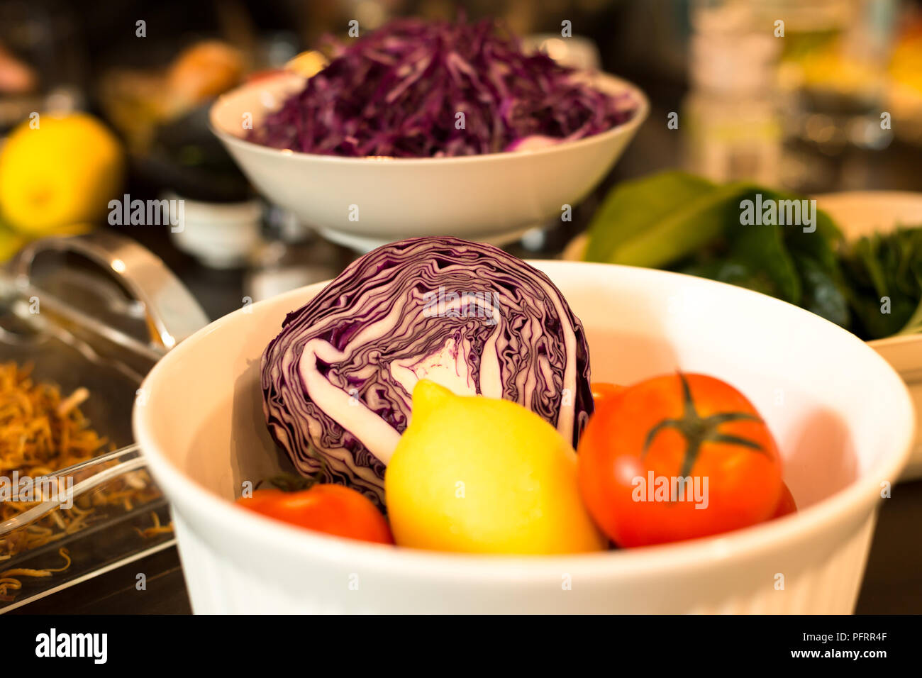 Red cabbage cut in half in white bowl with lemon and tomato isol Stock ...