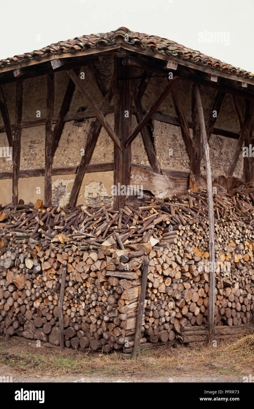 France, stacks of fire wood outside medieval timber framed barn Stock ...