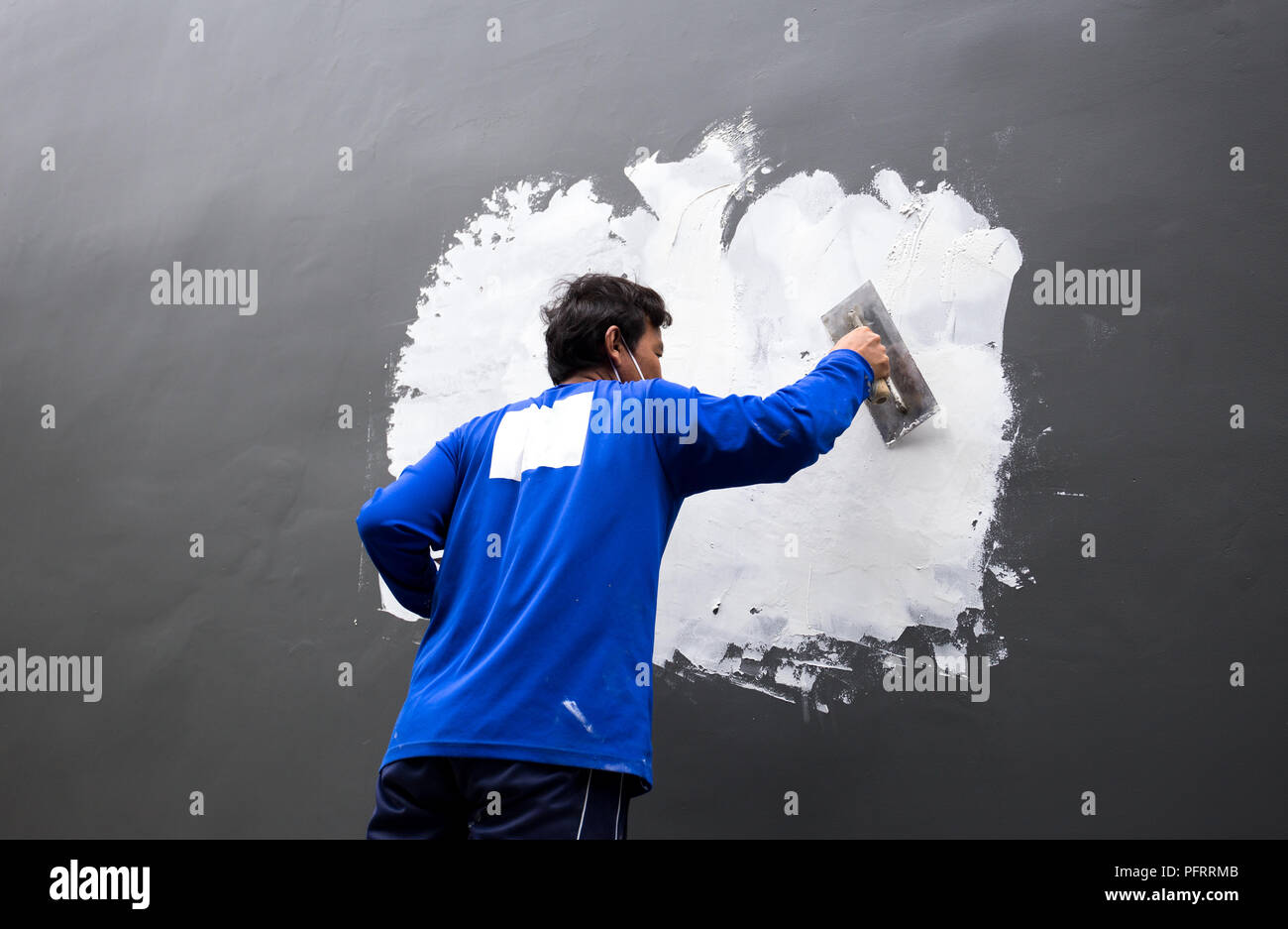 Builder plastering grey concrete at wall with white plaster Stock Photo ...