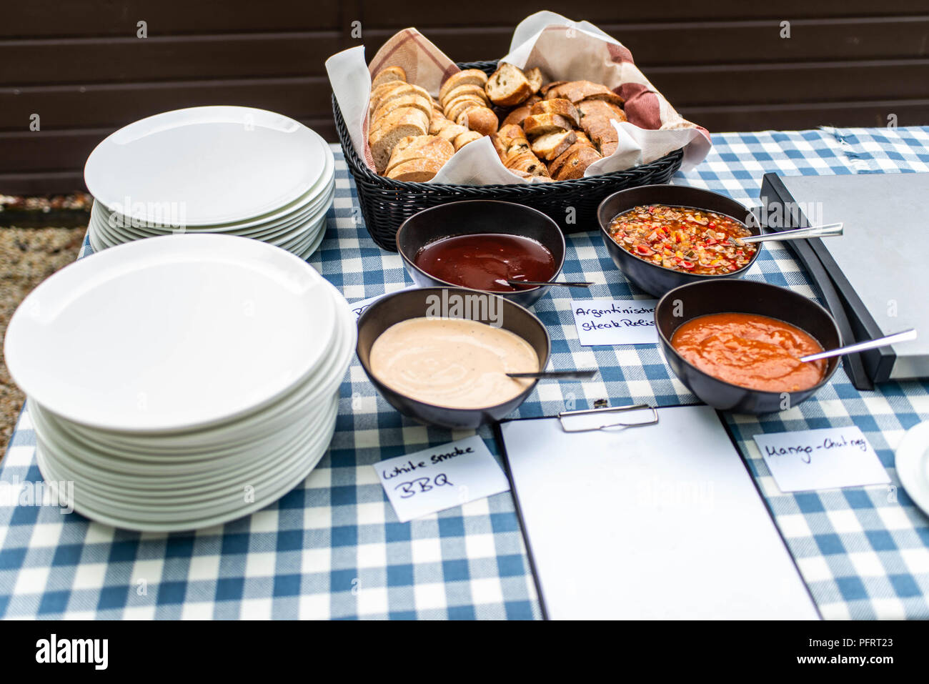various dip sauces on black bowls with white plates on dinner table ...