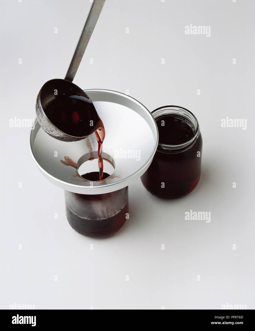 Jar being filled with liquid jelly, using a funnel Stock Photo - Alamy