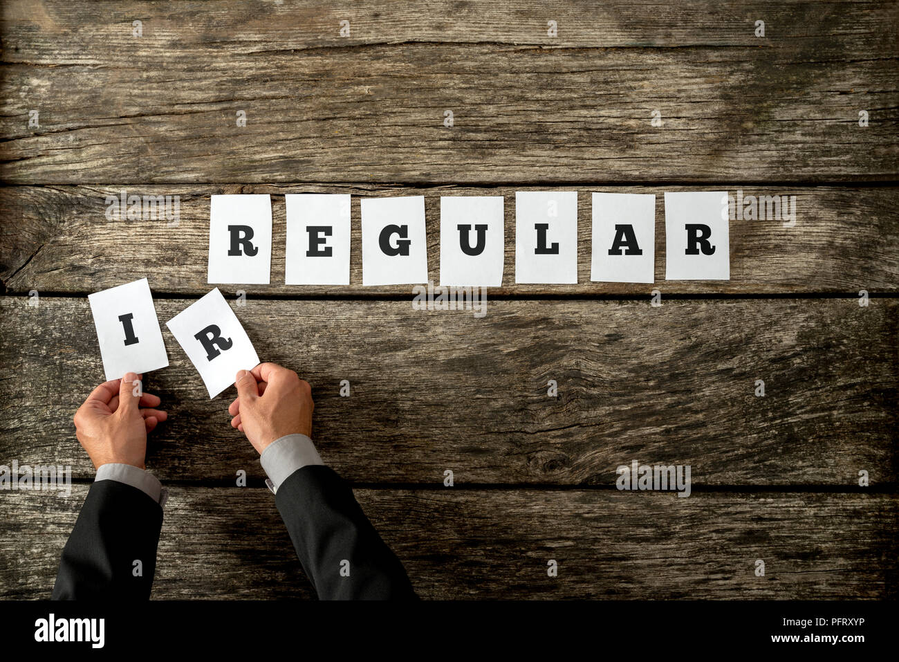 Top view of business man in suit removing letters IR from the word ...