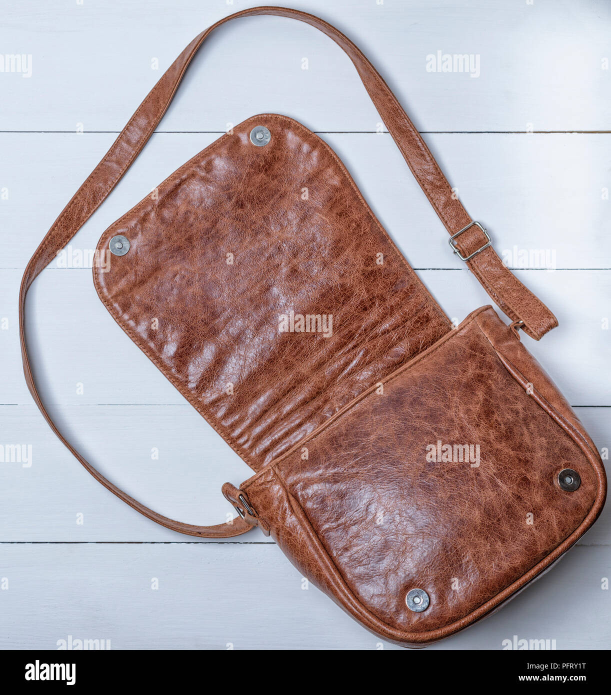 open female brown leather bag on a white wooden background, top view ...