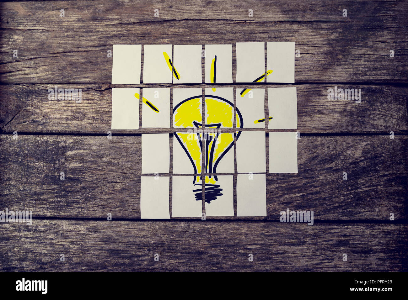 Top view of hand drawn yellow light bulb assembled with many cards over ...
