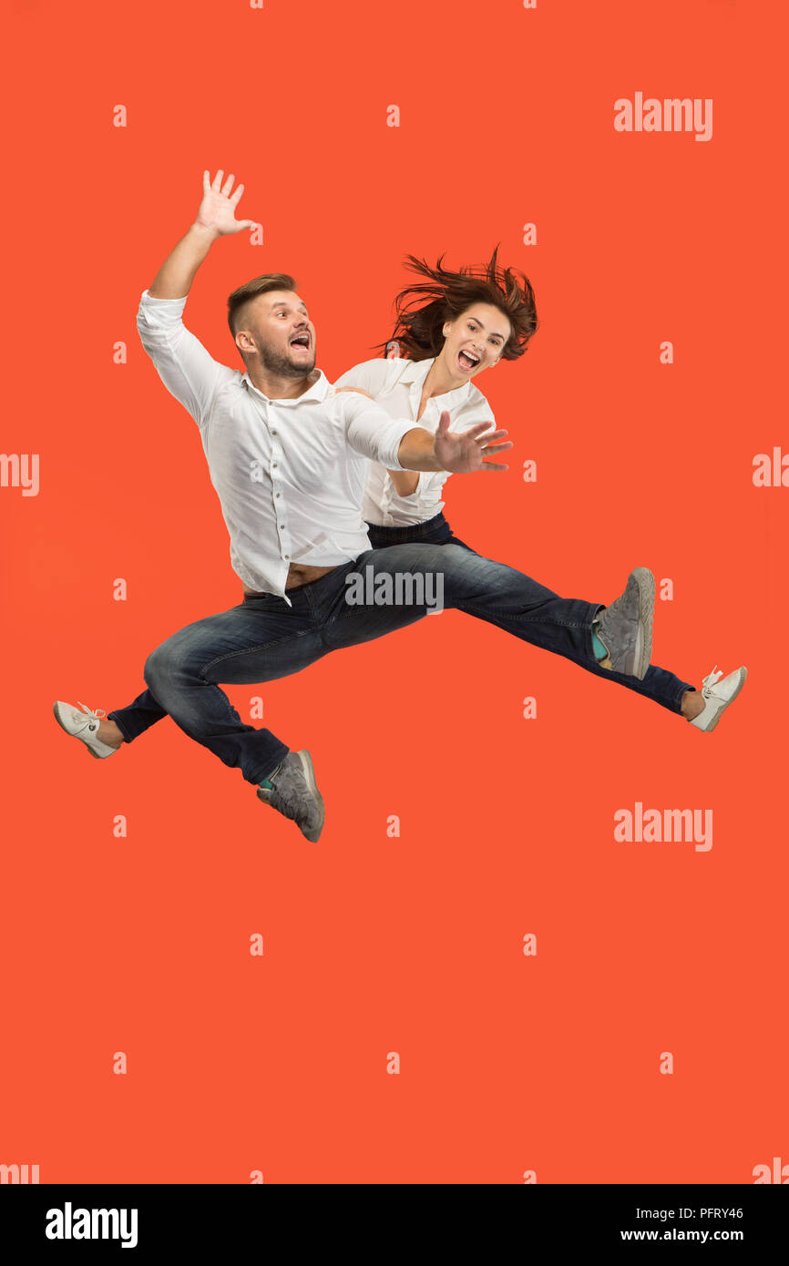 Freedom in moving. The happy young couple jumping and gesturing against ...
