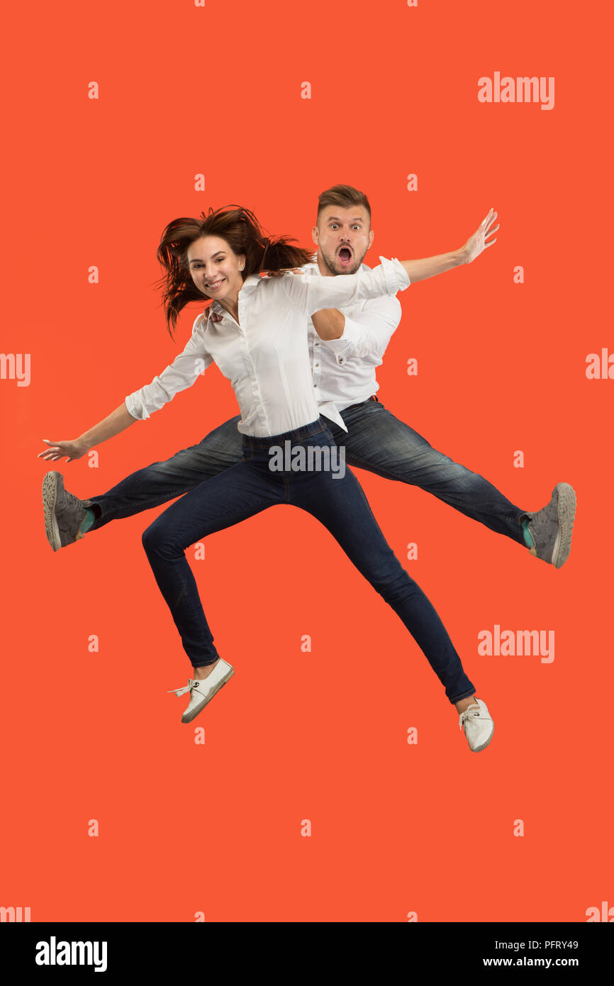 Freedom in moving. The happy young couple jumping and gesturing against ...