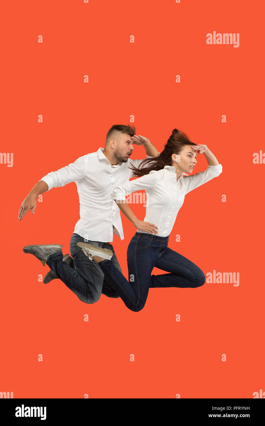 Freedom in moving. The happy young couple jumping and forward looking ...