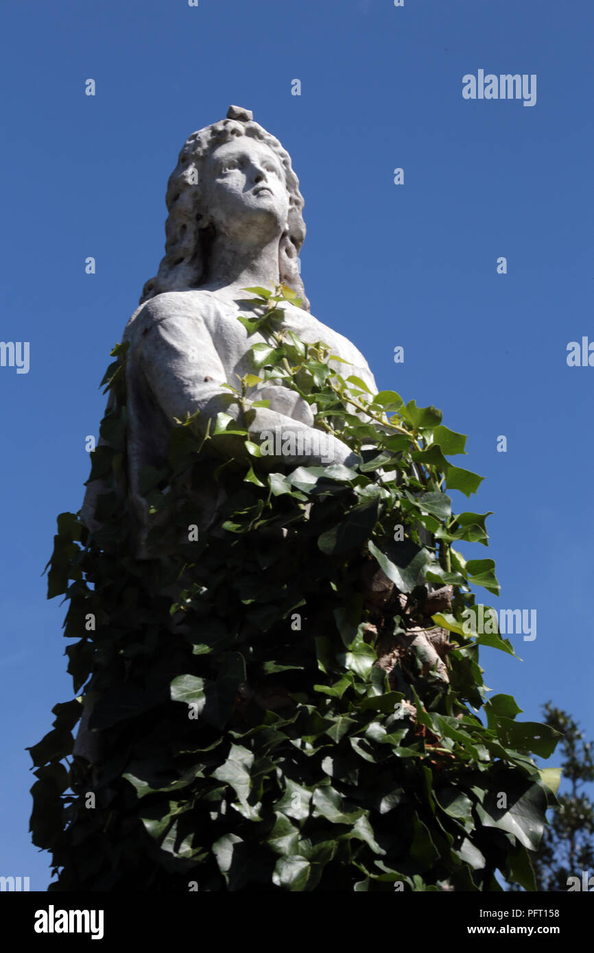 Statue of a woman partially covered in ivy Arnos Vale Cemetery ...