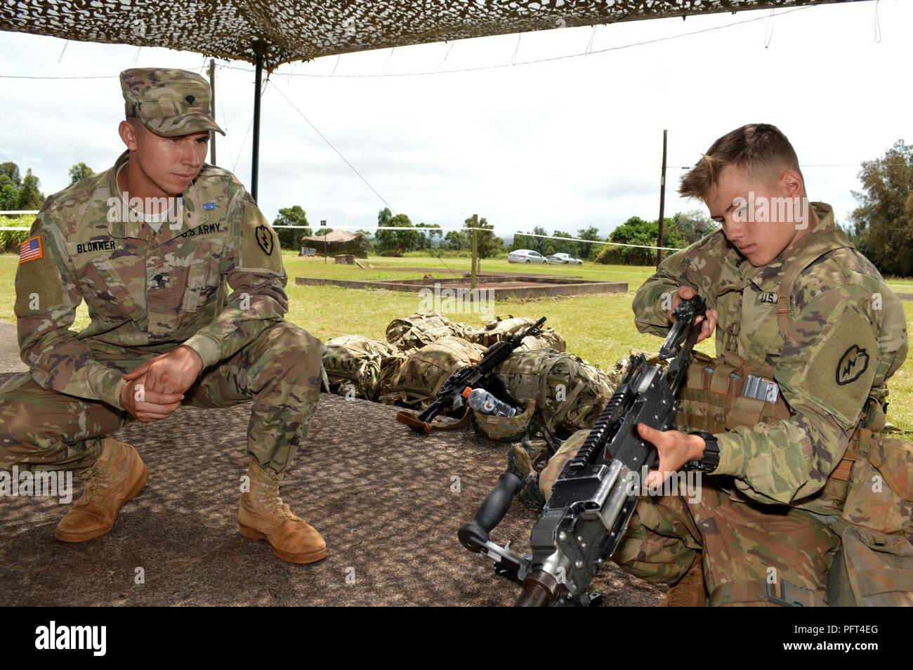 Spc. Richard Blommers (left) provides instruction to Pfc. Tyler Goodall ...