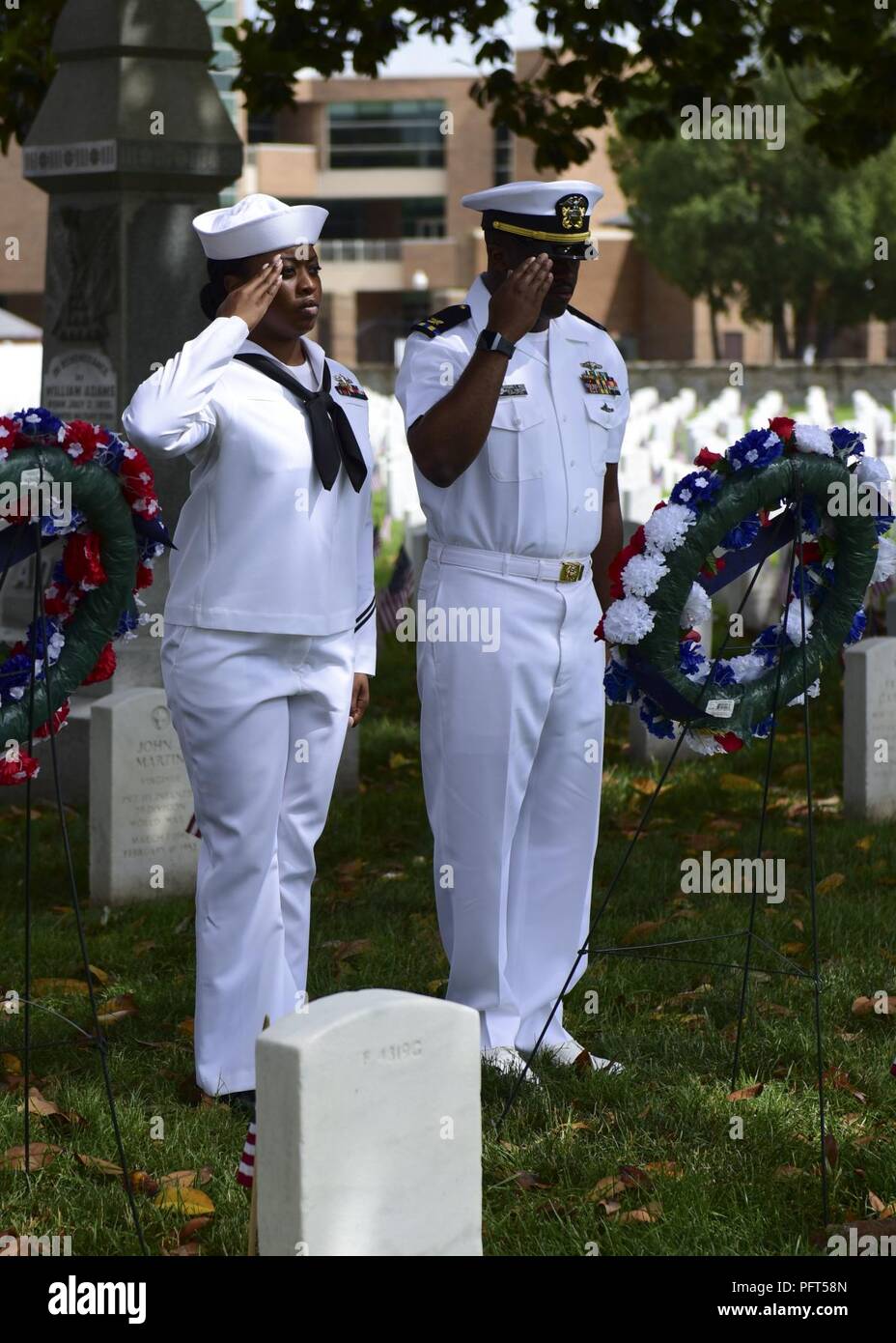 U.S. Navy Sailors render a salute after placing a ceremonial wreath ...
