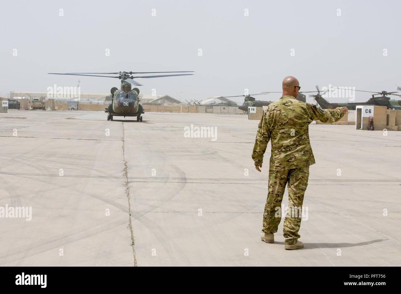 A U.S. Army aviator, with Task Force Hurricane, ground guides a Spanish ...