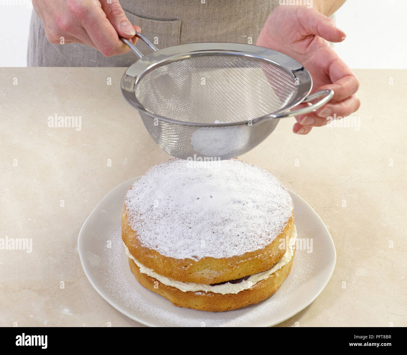 Sieving icing sugar on top of Victoria sponge cake Stock Photo - Alamy