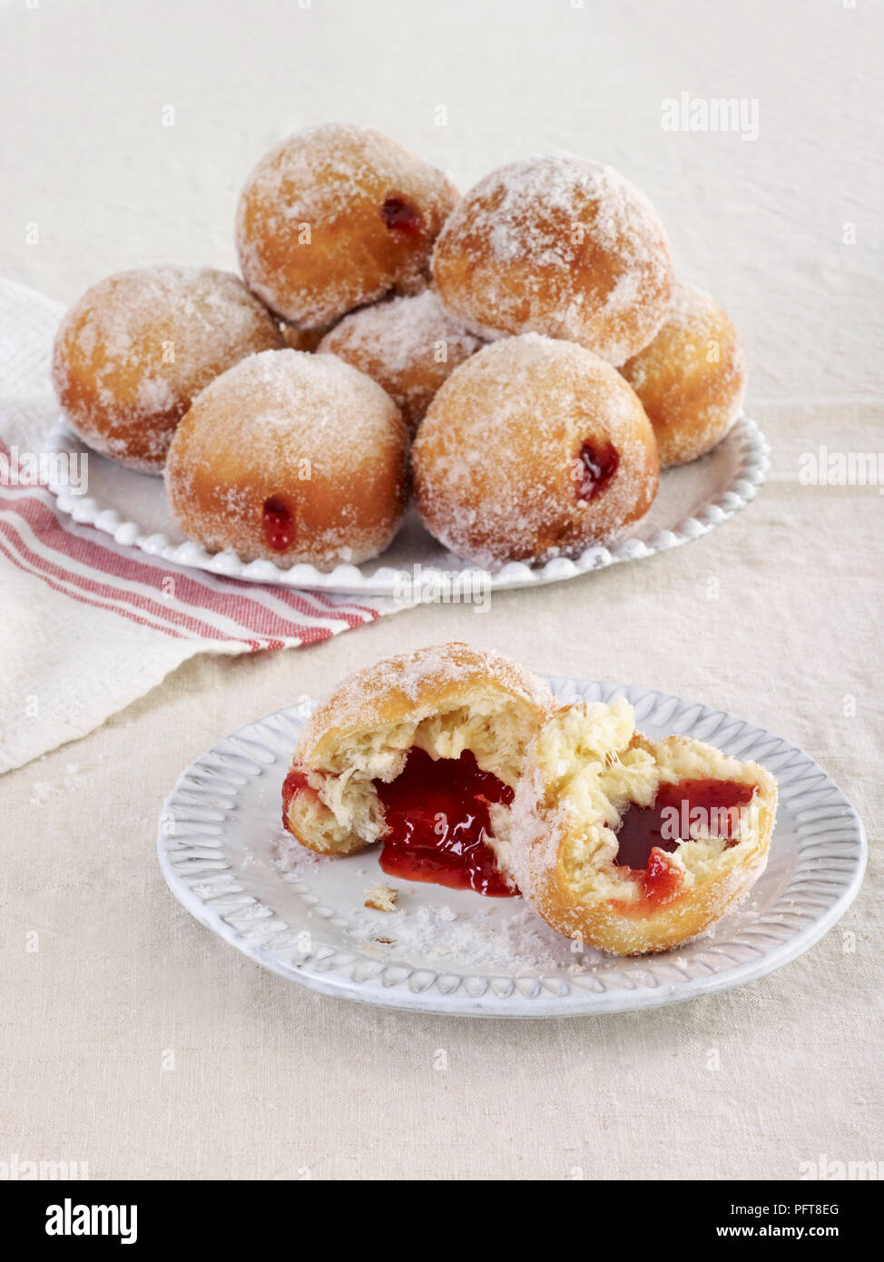 Raspberry jam donuts on plates, whole and open showing jam Stock Photo ...