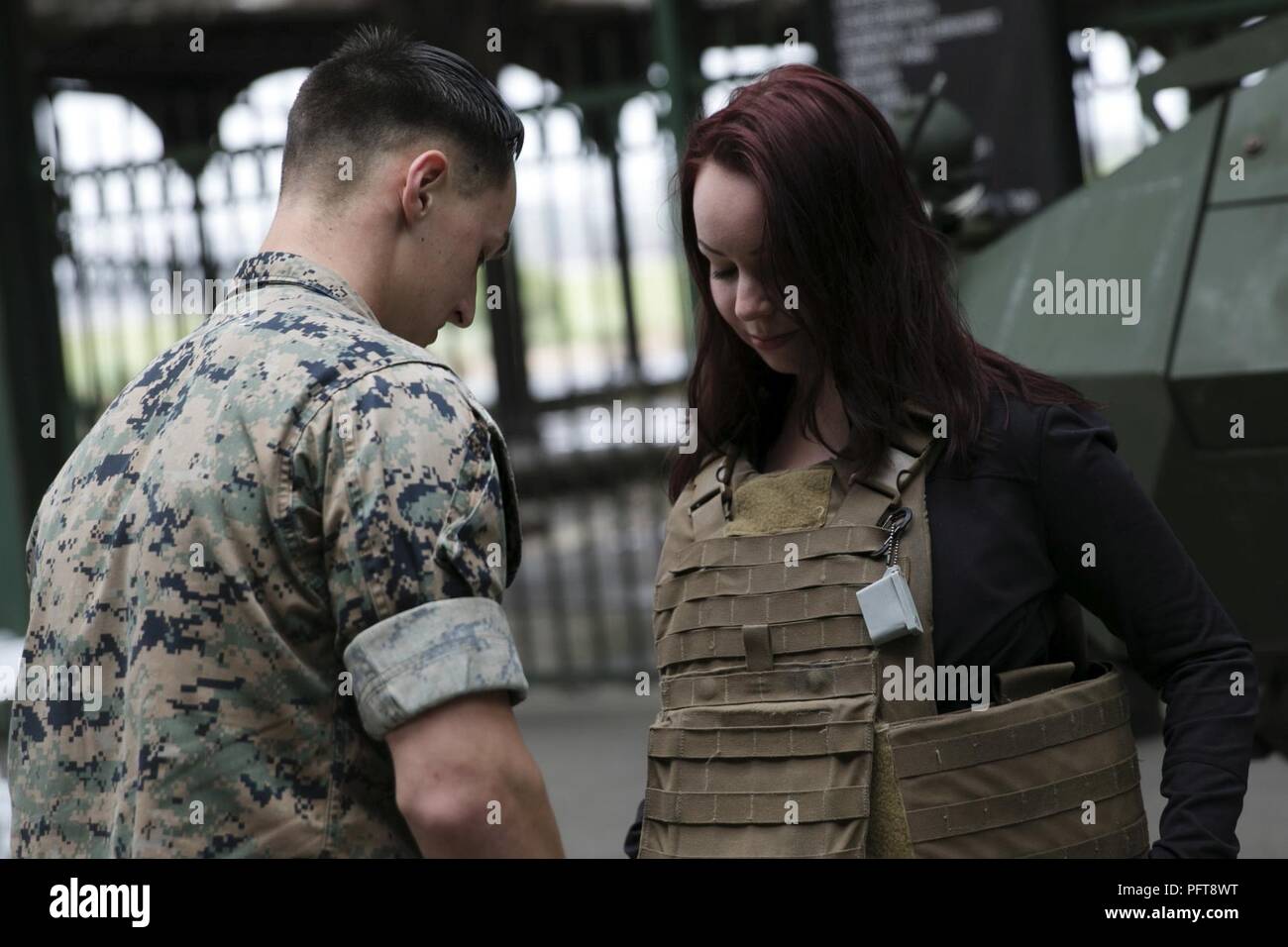 A Marine dresses an attendee in a United States Marine Corps flak ...