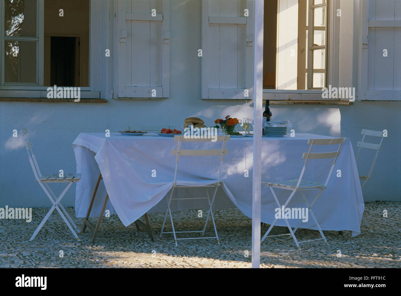 Table set for dining outside house in shade Stock Photo - Alamy