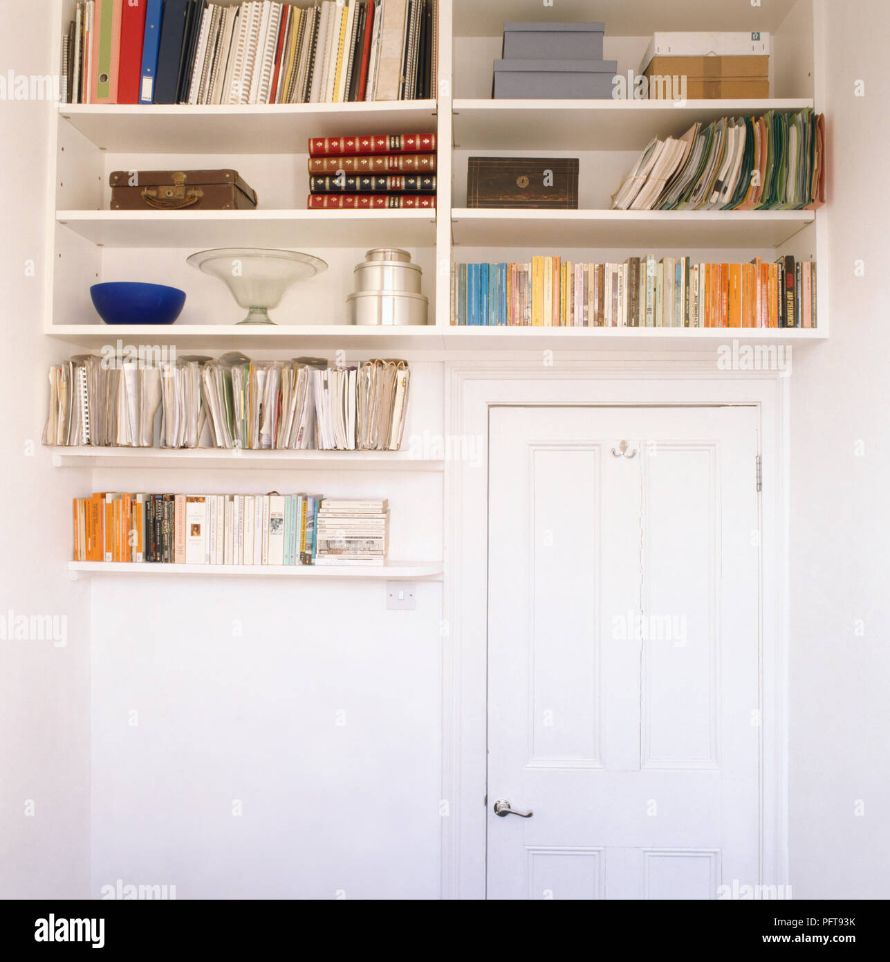 Book and storage shelves in room with closed door Stock Photo - Alamy