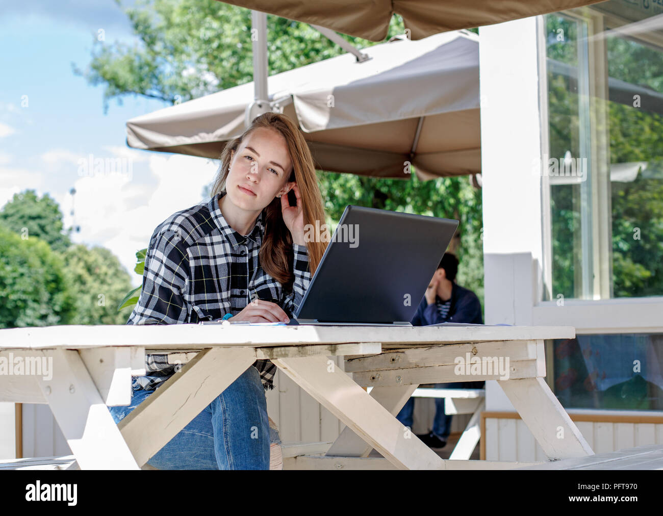 Attractive young woman student using laptop outside Stock Photo - Alamy