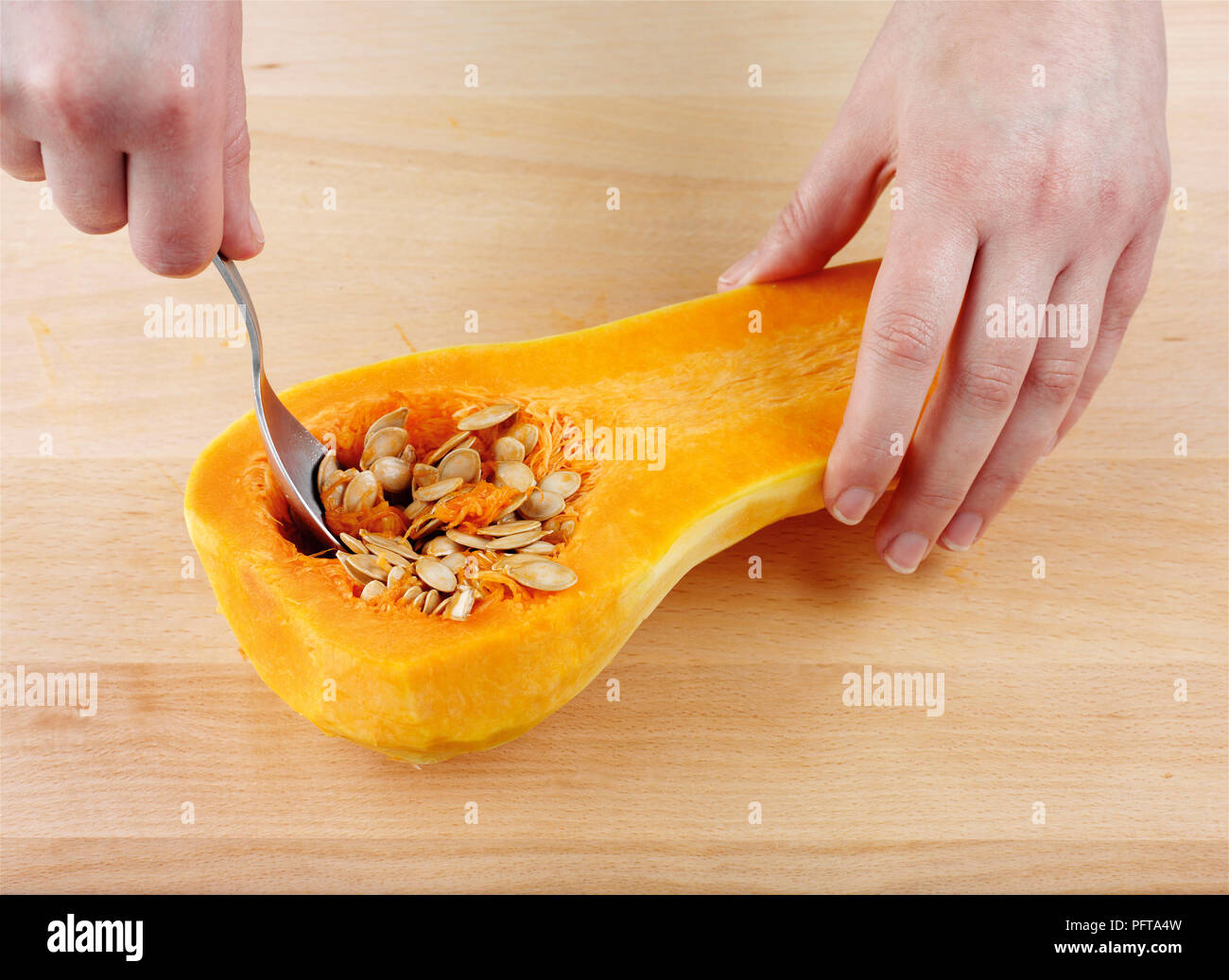 Seeding butternut squash, using a spoon Stock Photo - Alamy