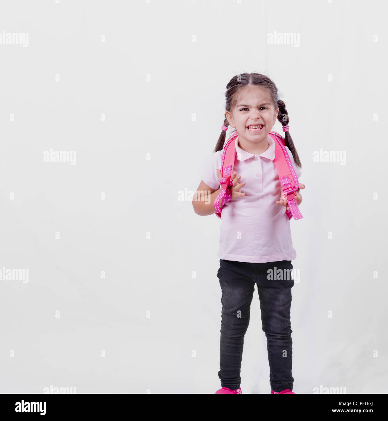 Portrait of cute unhappy and angry girl in school uniform not want to ...