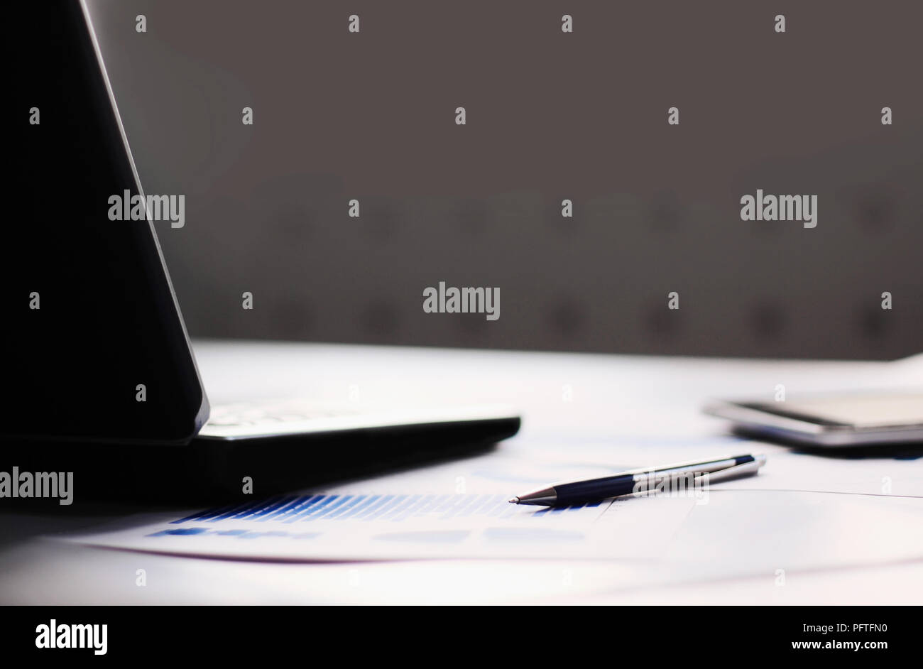 business background: laptop,financial chart and pen on office workplace ...