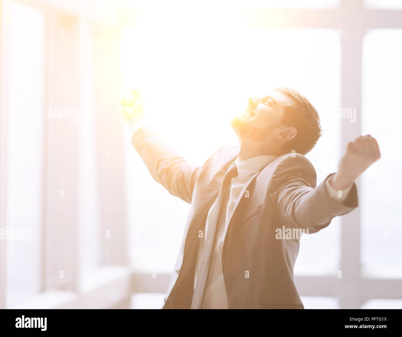 triumphant businessman standing in the office.photo with copy space ...