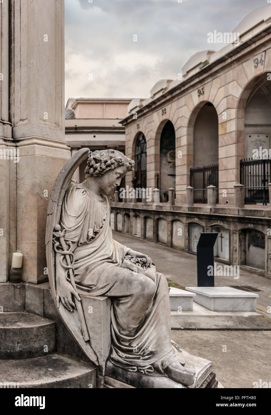 Male angel sculpture sitting at crypt in Poblenou Cemetery. Peaceful ...