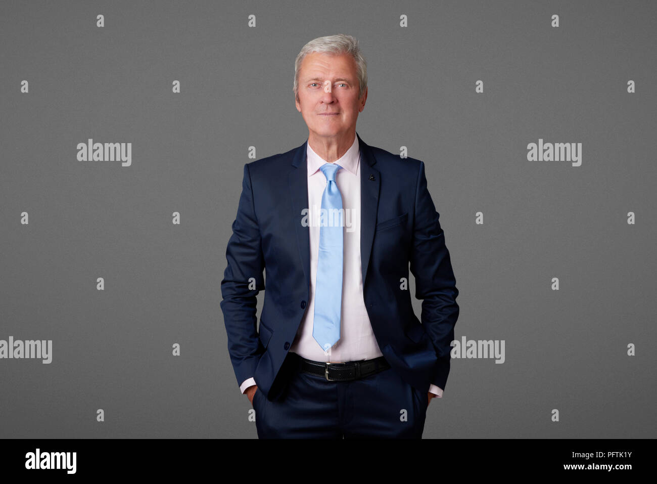 Portrait of a senior professional man standing at isolated background ...