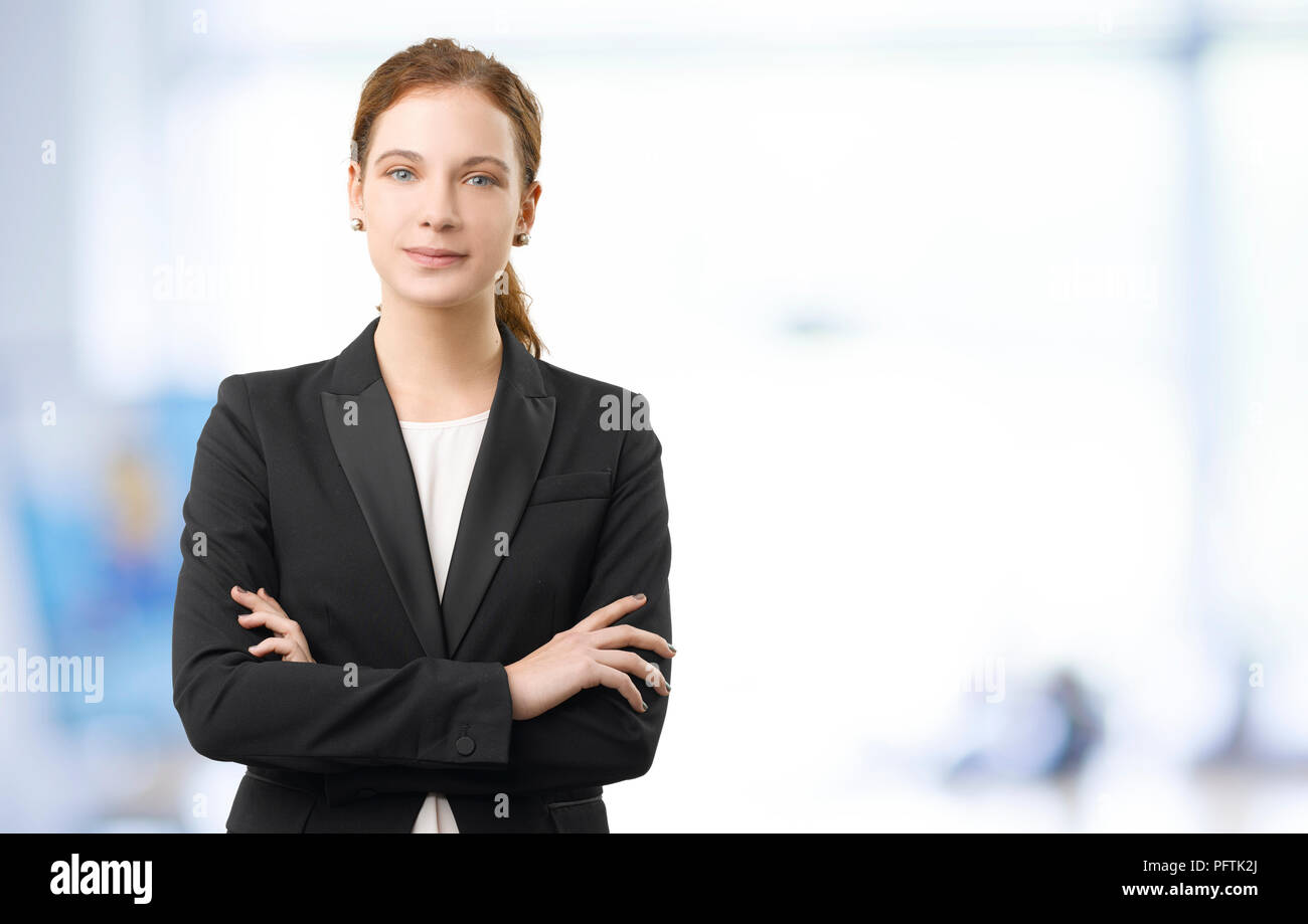 Shot of a young financial assistant standing in the office with arms ...
