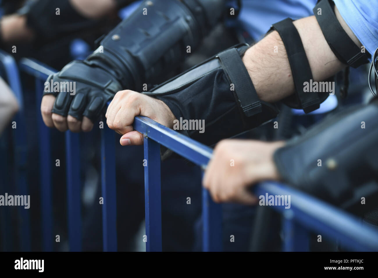 Police officer hands on a security fence during a riot Stock Photo - Alamy