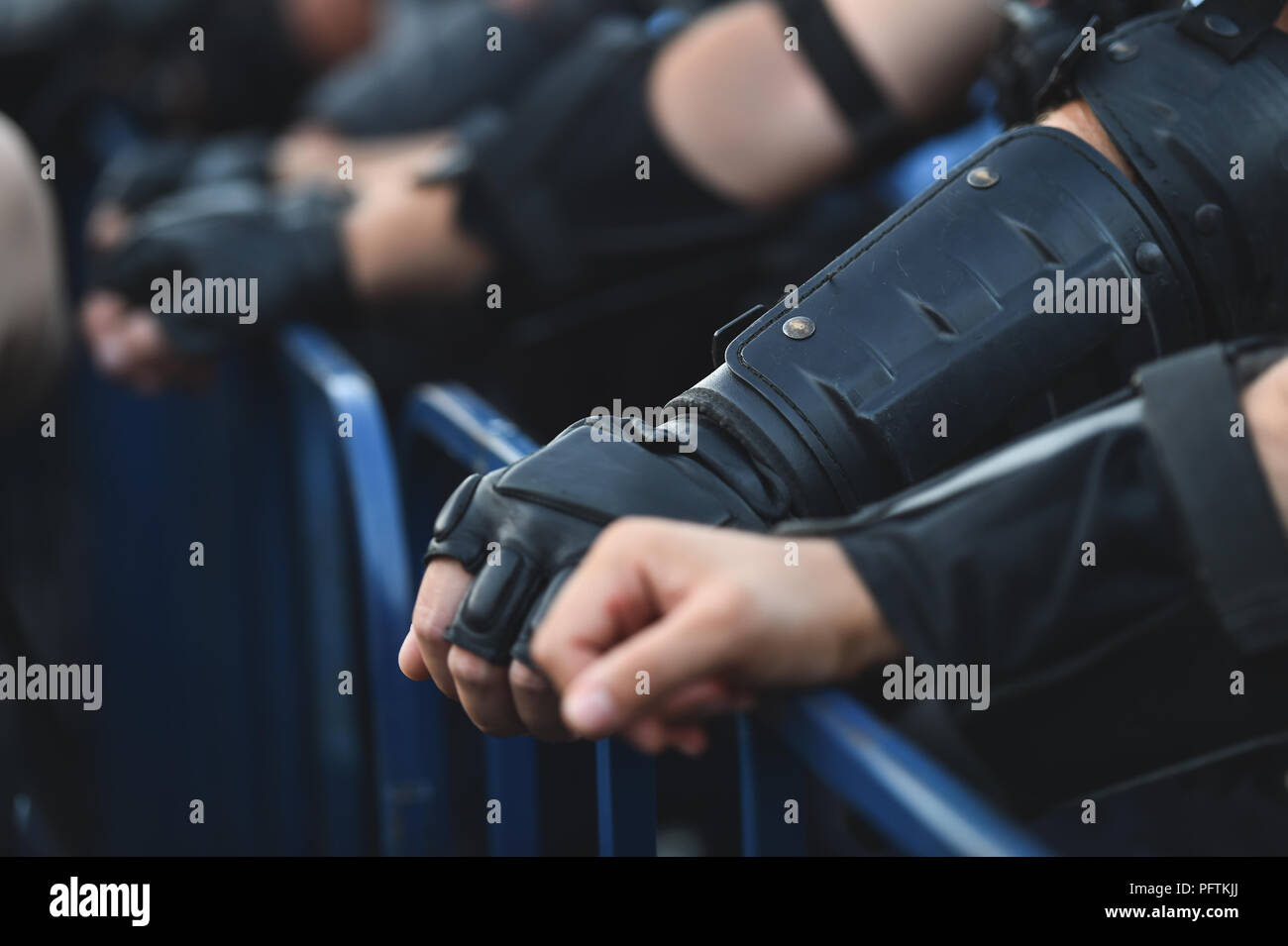 Police officer hands on a security fence during a riot Stock Photo - Alamy