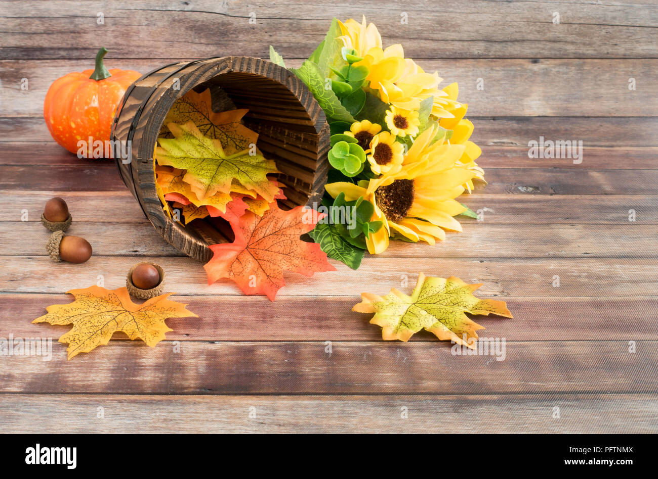 Sunflower bouquet, pumpkin, acorns and a rustic wooden plant pot filled ...